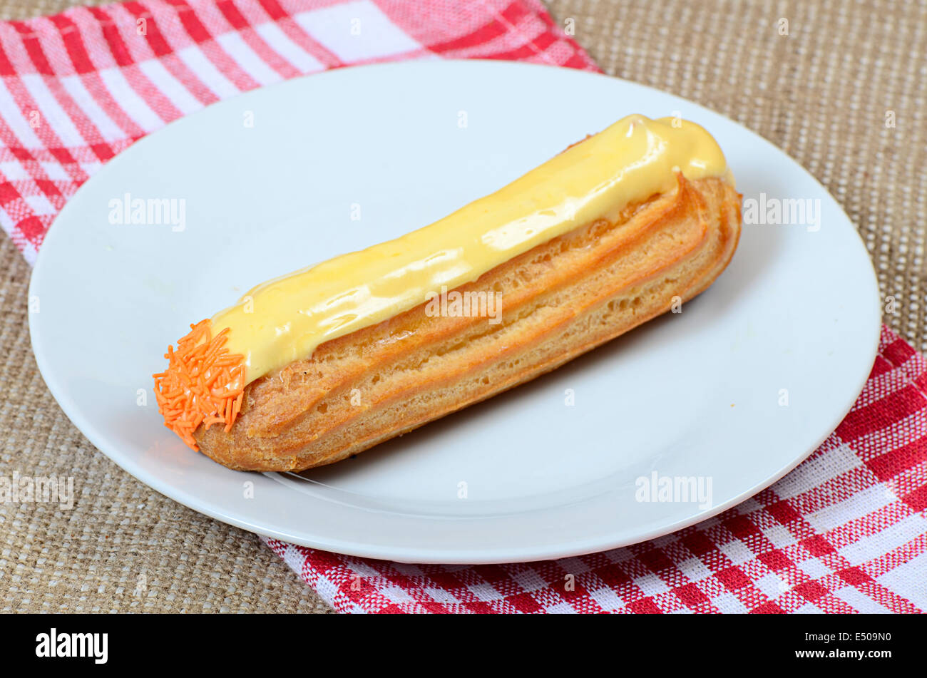 Eclair with a cream on a plate Stock Photo - Alamy