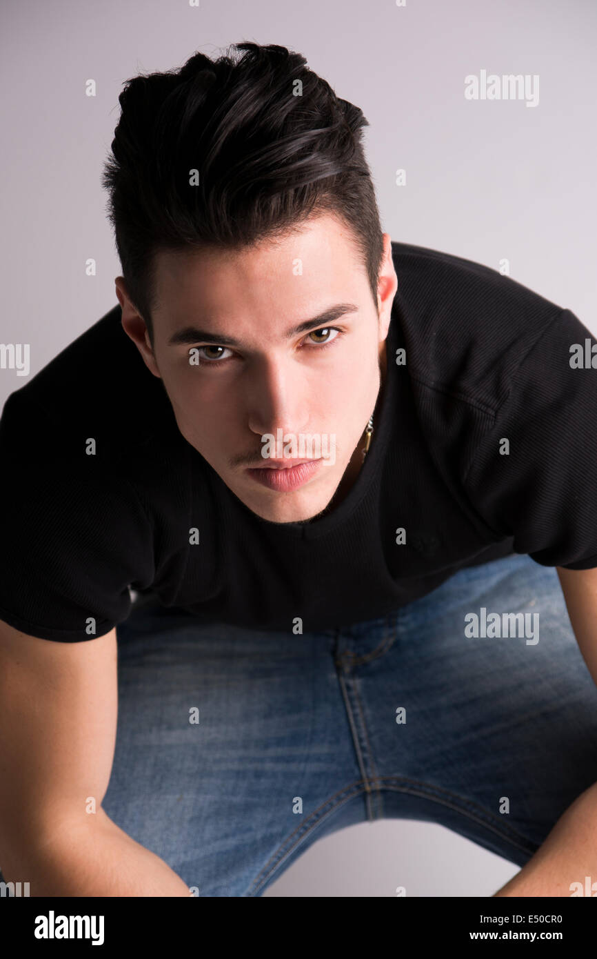 Handsome young man sitting, seen from above, looking at camera Stock ...