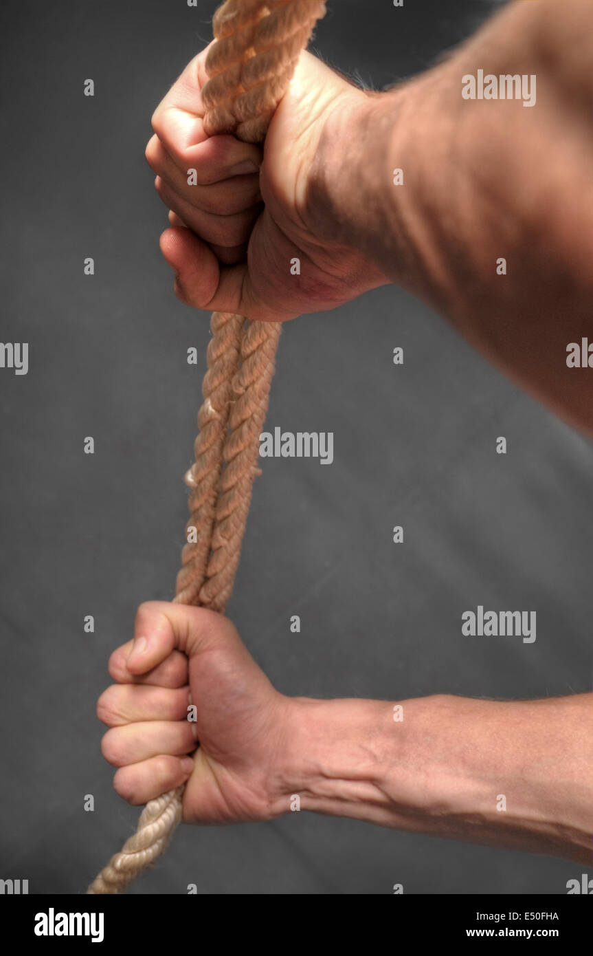 Hands pulling rope over dark background Stock Photo - Alamy