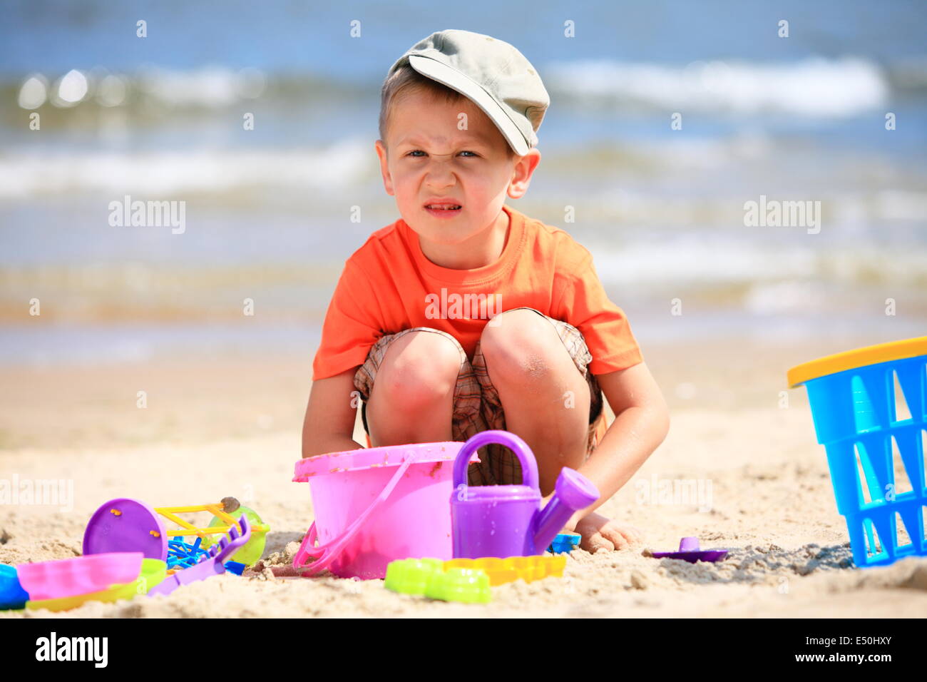 Boy on the beach playing with sand hi-res stock photography and images ...