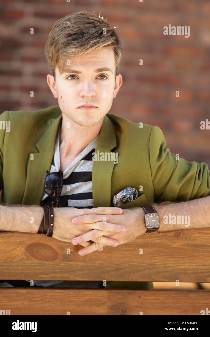 Young handsome man sitting on bench Stock Photo - Alamy