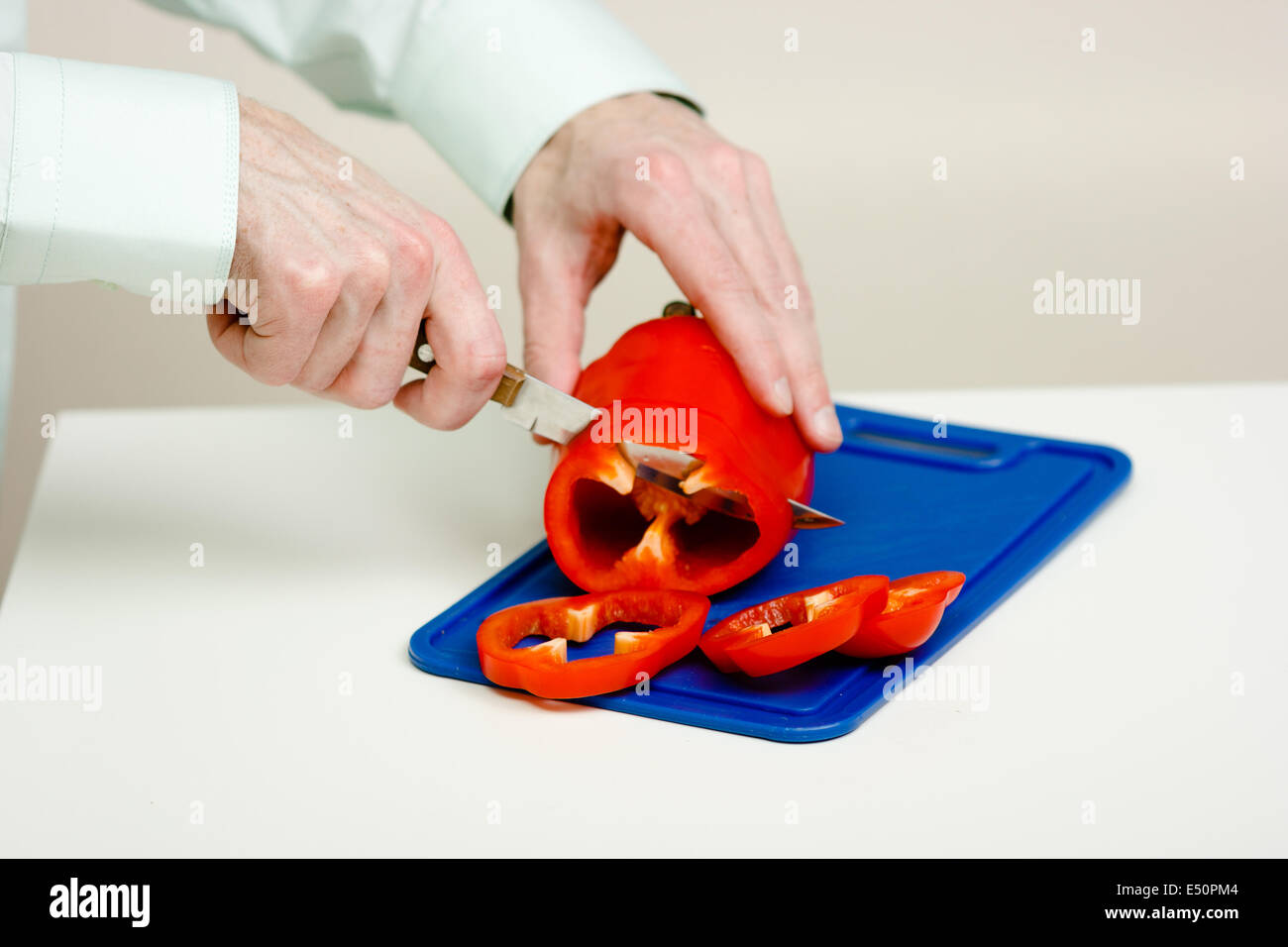 Man's hand cut red pepper Stock Photo - Alamy