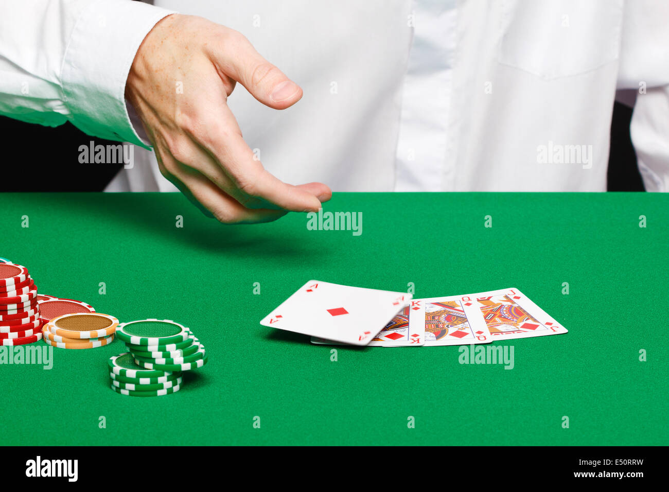 player's hand throws a playing card Stock Photo - Alamy