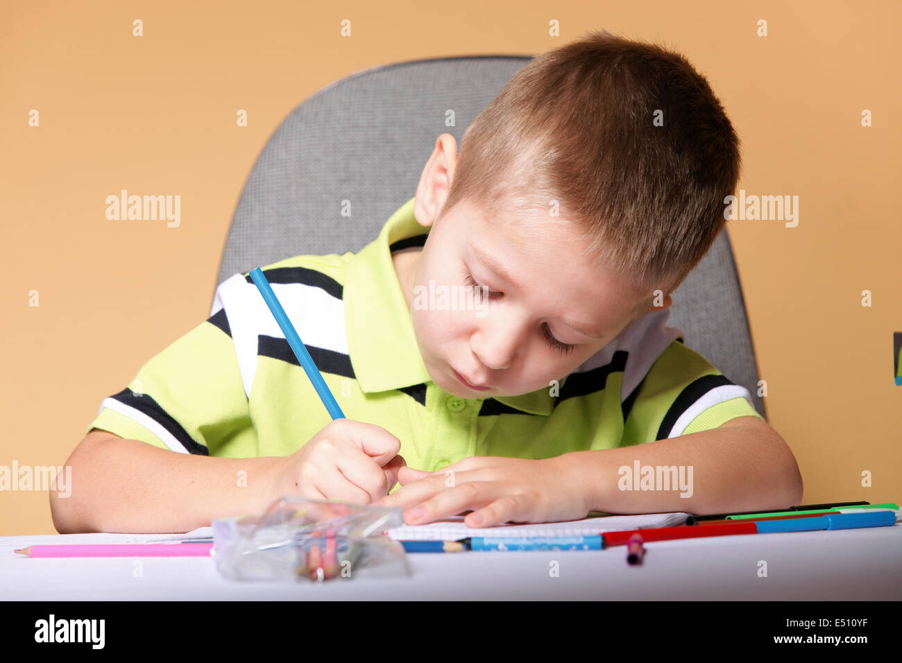 Young cute boy draws with color pencils Stock Photo - Alamy