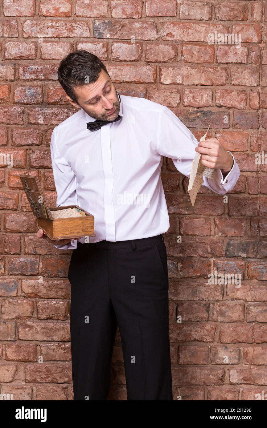 Man reading a document from a wooden box Stock Photo - Alamy