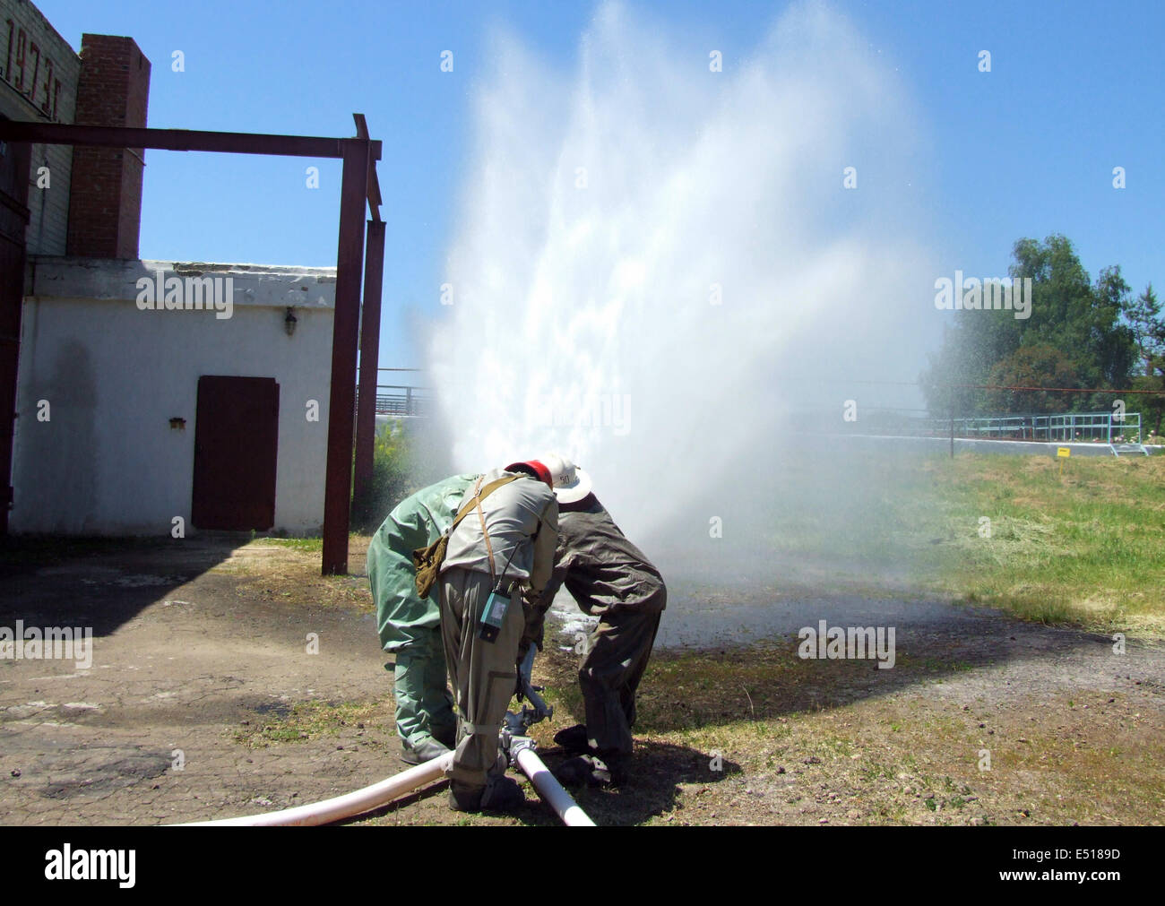 Fireman spraying water Stock Photo - Alamy