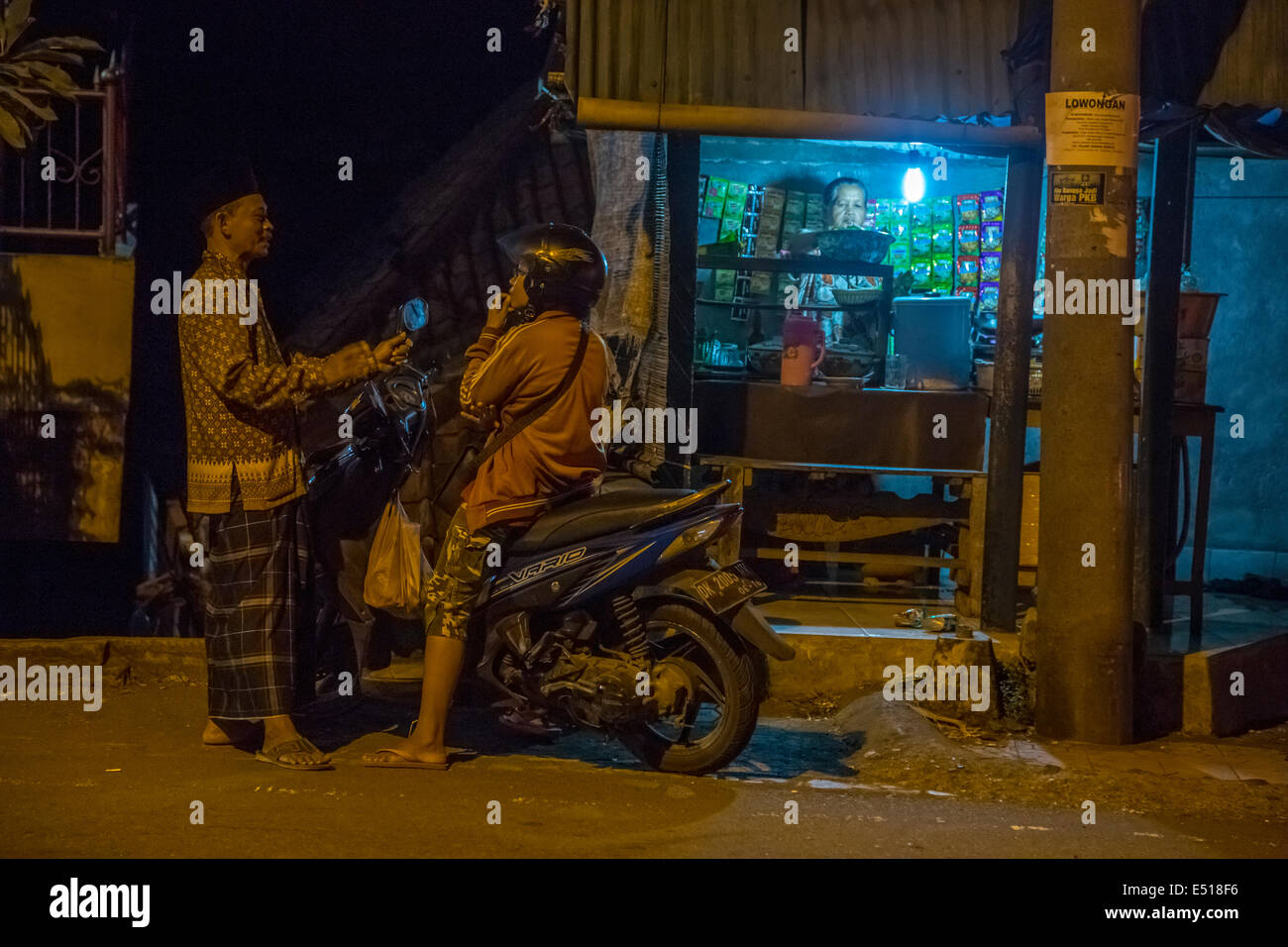 Bali, Indonesia. Two Men Talking at Night outside a Refreshment Stand ...