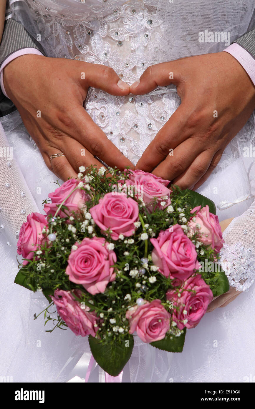Hands of bride and groom in a heart shape Stock Photo - Alamy
