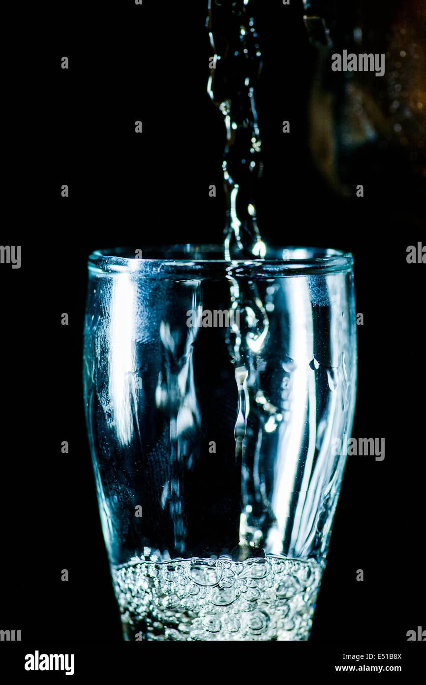 glass pouring drink on black Stock Photo - Alamy