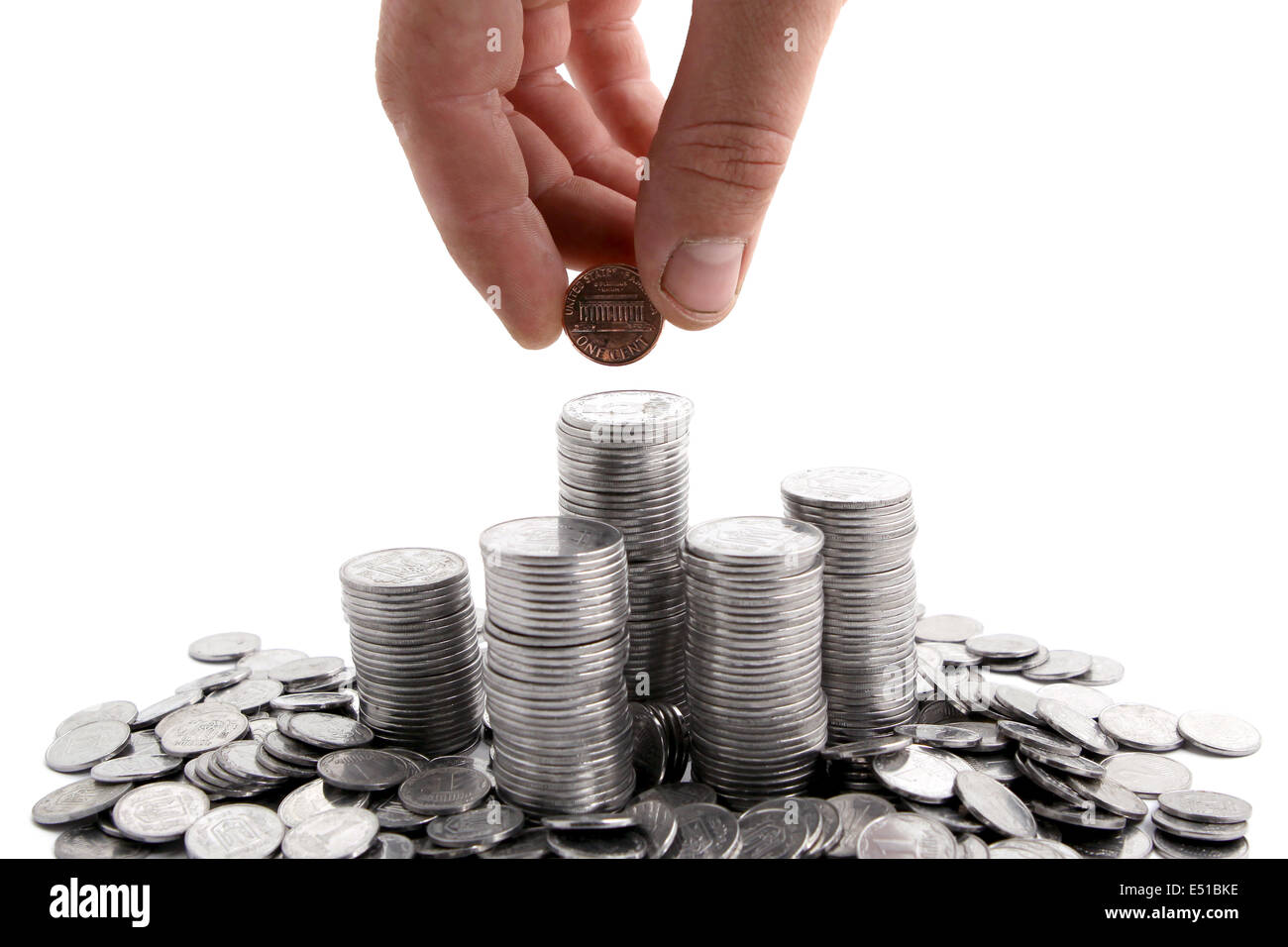 Hand adding coins Stock Photo - Alamy