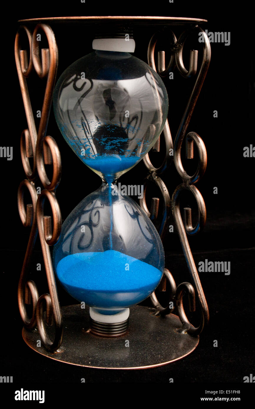 Hourglass with blue sand Stock Photo - Alamy