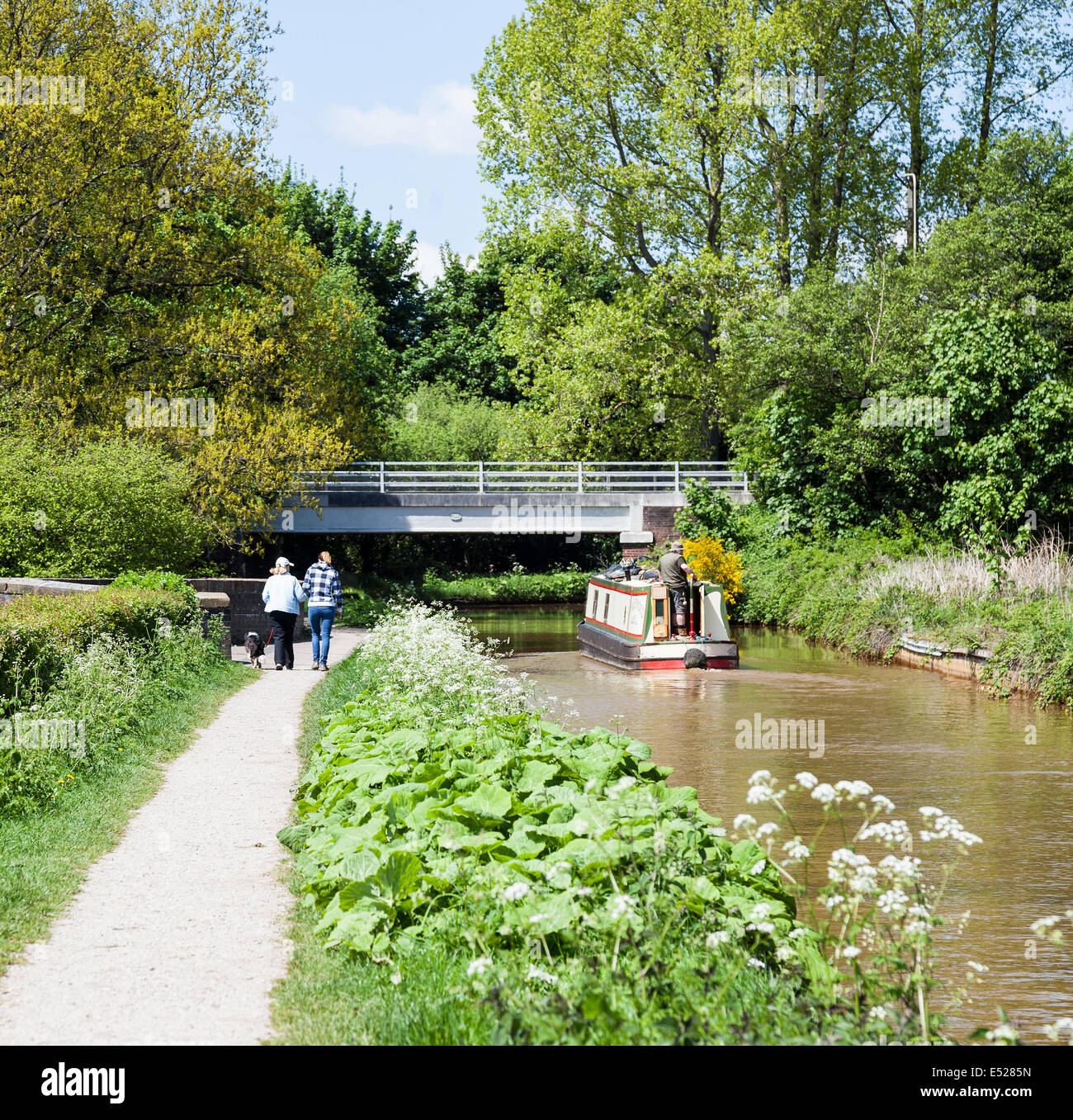 People walking on the towpath with a barge or narrow boat on the Trent ...