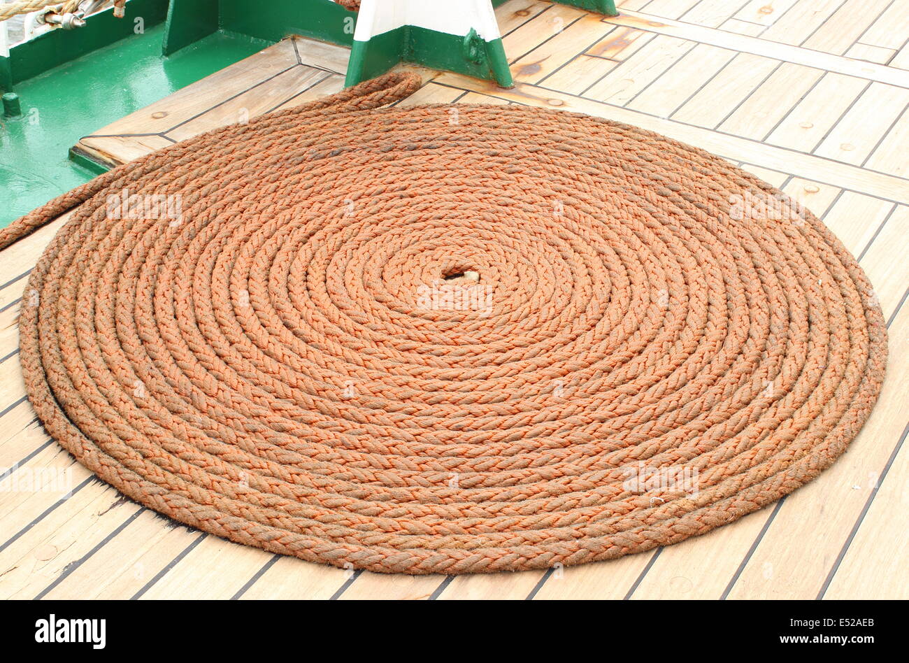 Old nautical thick rope wrapped in spiral lying on weathered deck of ...