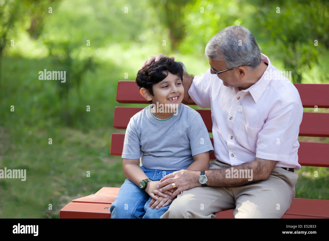 Grandfather and grandson sitting in a park Stock Photo - Alamy
