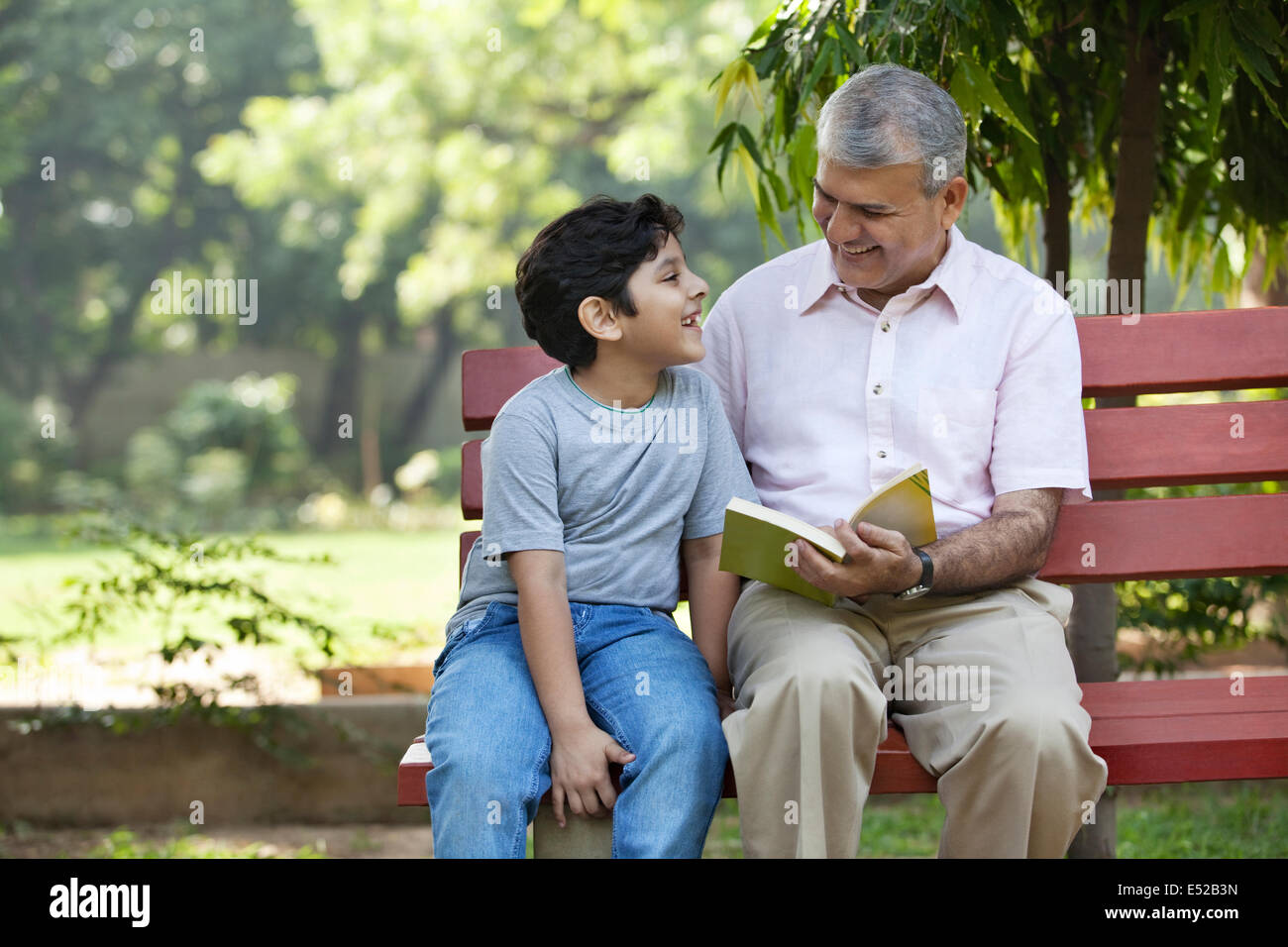 Grandfather and grandson sitting in a park Stock Photo - Alamy