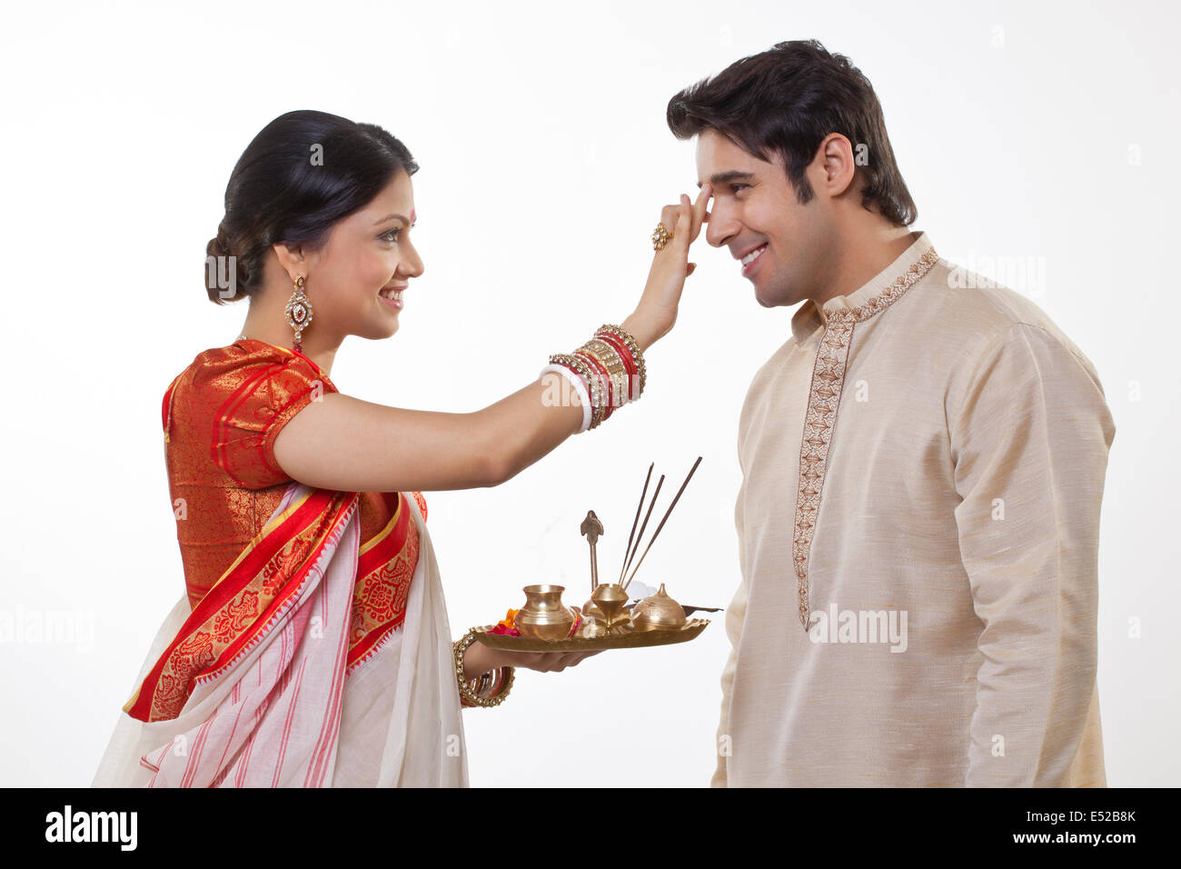 Bengali woman putting tika on man's head Stock Photo - Alamy