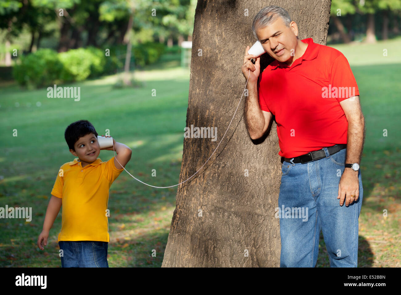 Grandfather and grandson talking through paper cups Stock Photo - Alamy