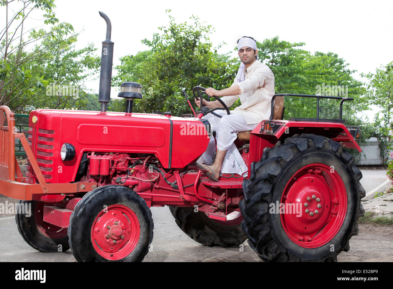 Portrait of a farmer sitting on a tractor Stock Photo - Alamy