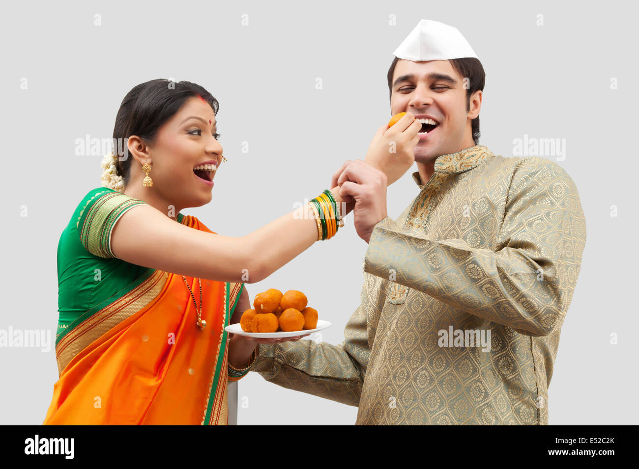 Maharashtrian woman feeding man a laddoo Stock Photo - Alamy