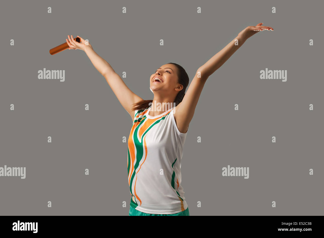Female relay runner celebrating victory isolated over gray background ...