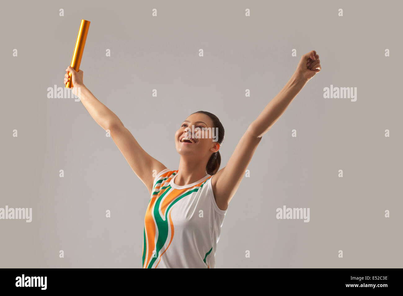 Female relay runner celebrating victory isolated over gray background ...