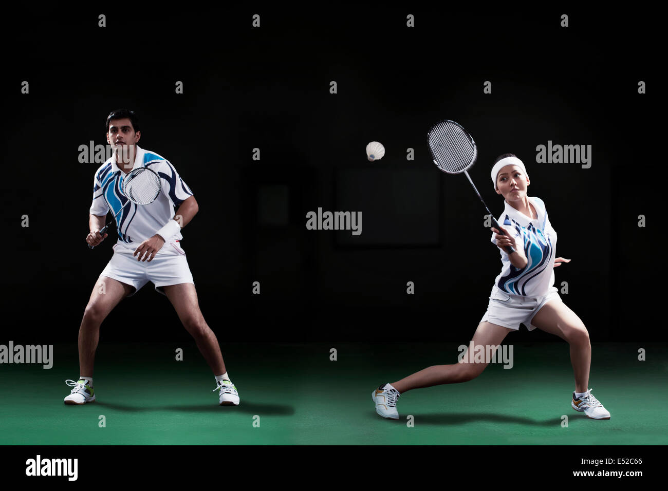Man and woman playing badminton doubles at court Stock Photo - Alamy