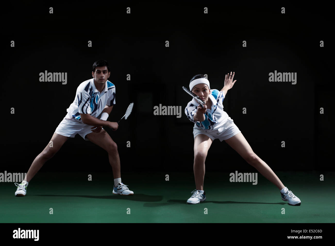 Man and woman playing badminton doubles at court Stock Photo - Alamy