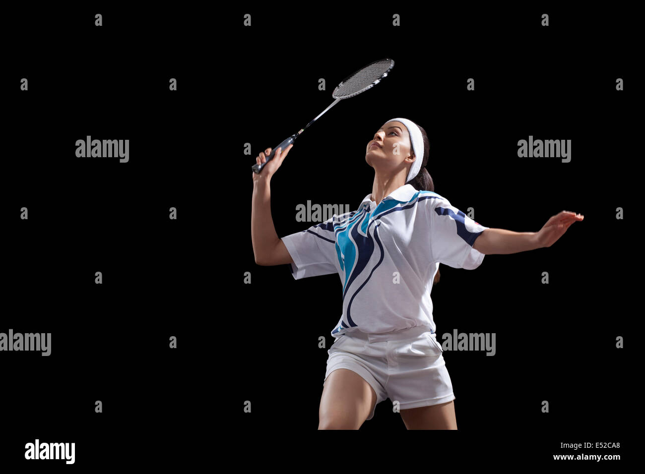 Young woman holding badminton racket isolated over black background ...