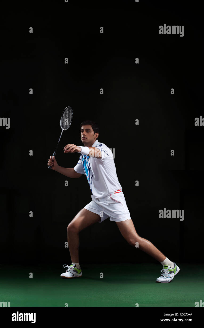 Full length of man holding badminton racket at court Stock Photo - Alamy
