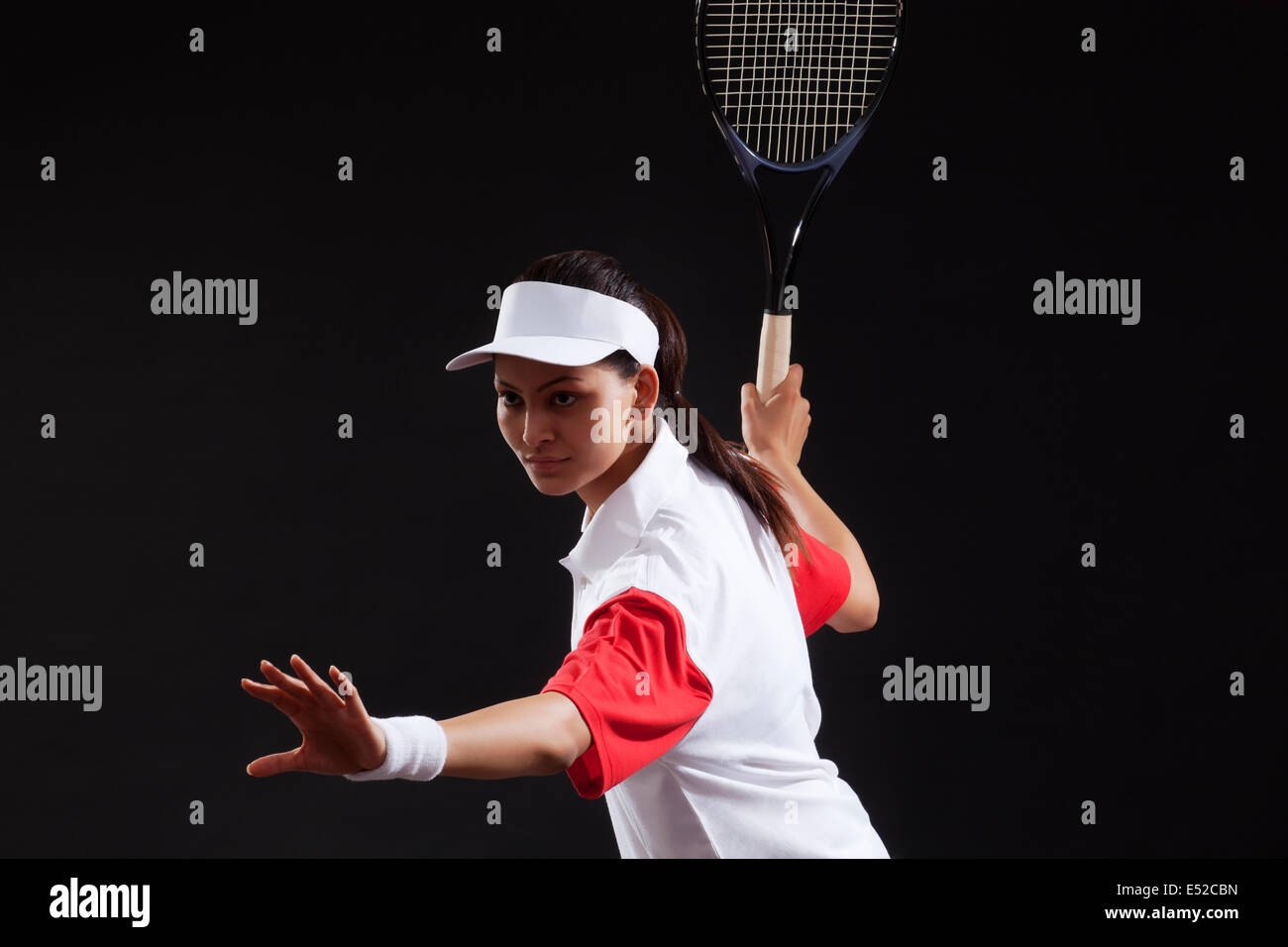 Young woman holding tennis racket isolated over black background Stock ...
