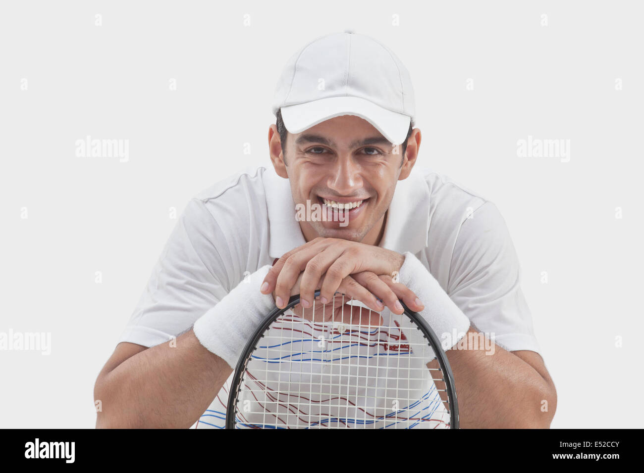 Portrait of male tennis player with racket isolated over gray ...