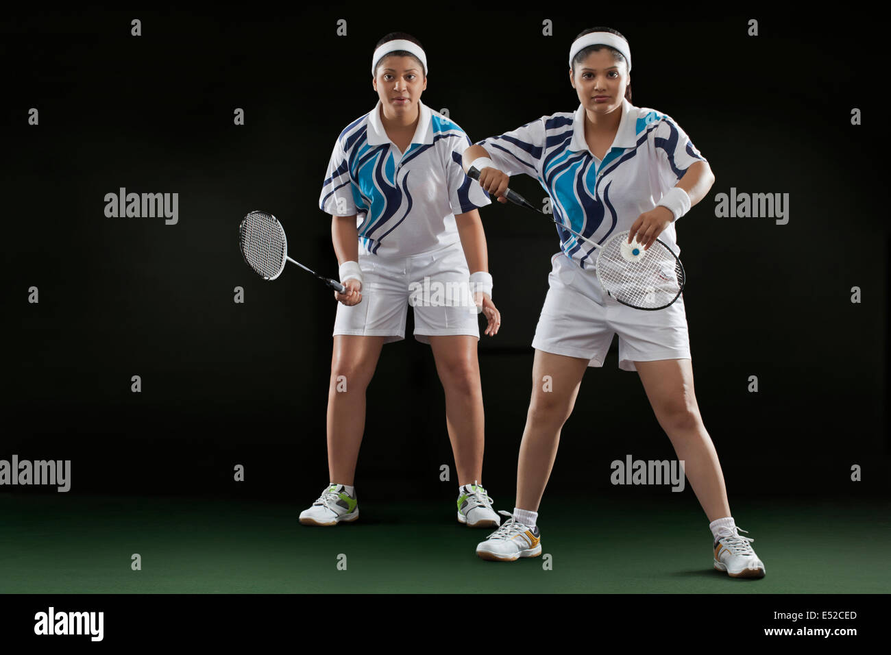 Female partners playing badminton over black background Stock Photo - Alamy