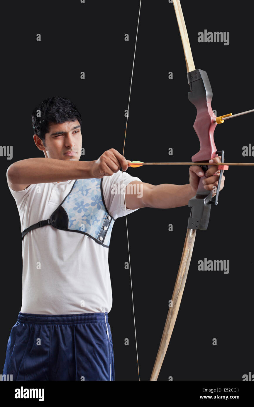 Male archer aiming over black background Stock Photo - Alamy