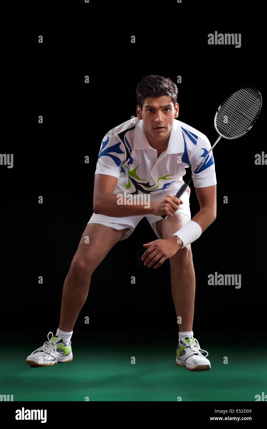 Young man playing badminton over black background Stock Photo - Alamy