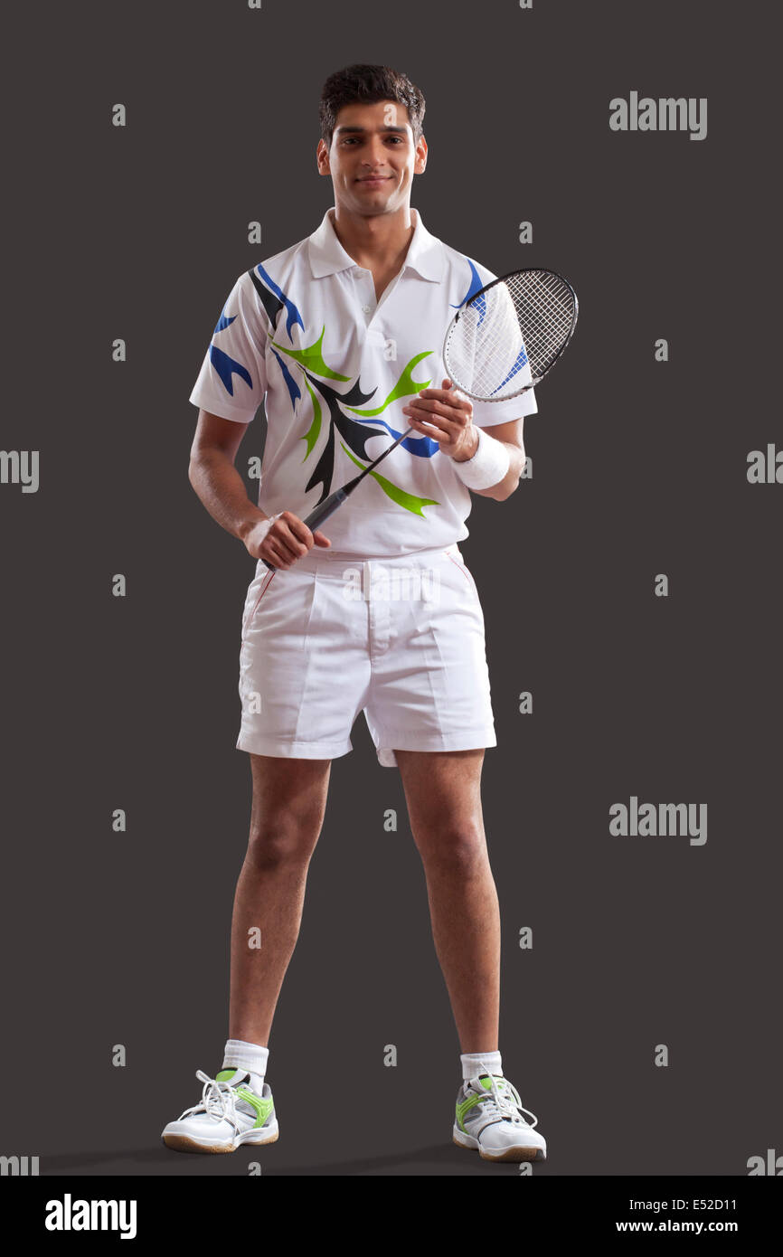 Full length portrait of confident young man with tennis racket standing ...
