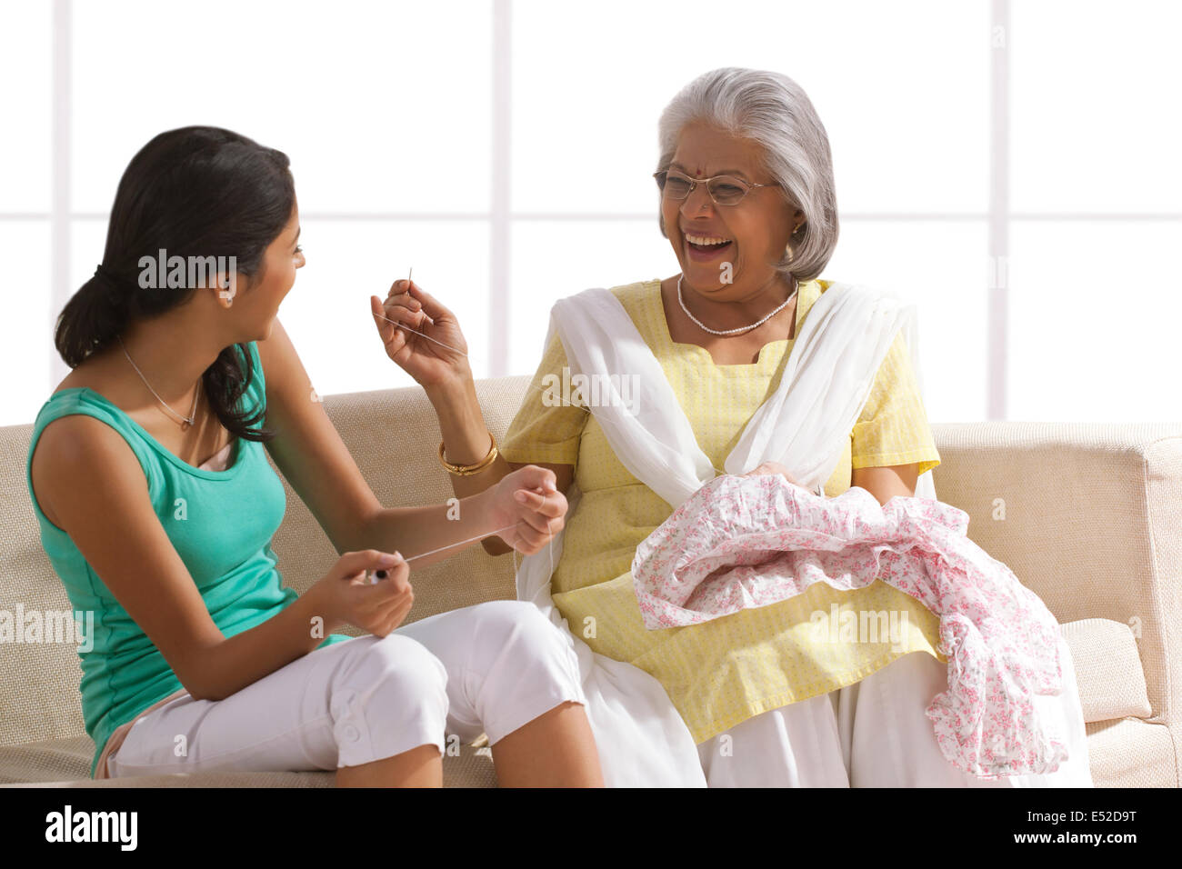Grandmother teaching granddaughter how to sew Stock Photo - Alamy