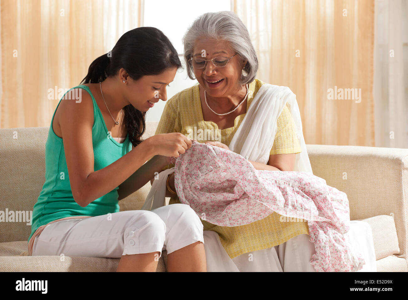 Grandmother teaching granddaughter how to sew Stock Photo - Alamy