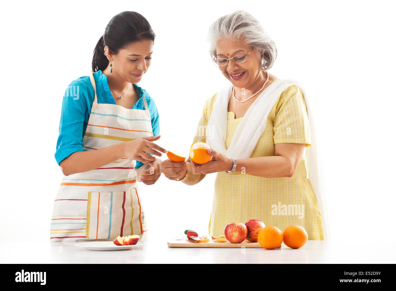 Grandmother and granddaughter cutting fruits Stock Photo - Alamy