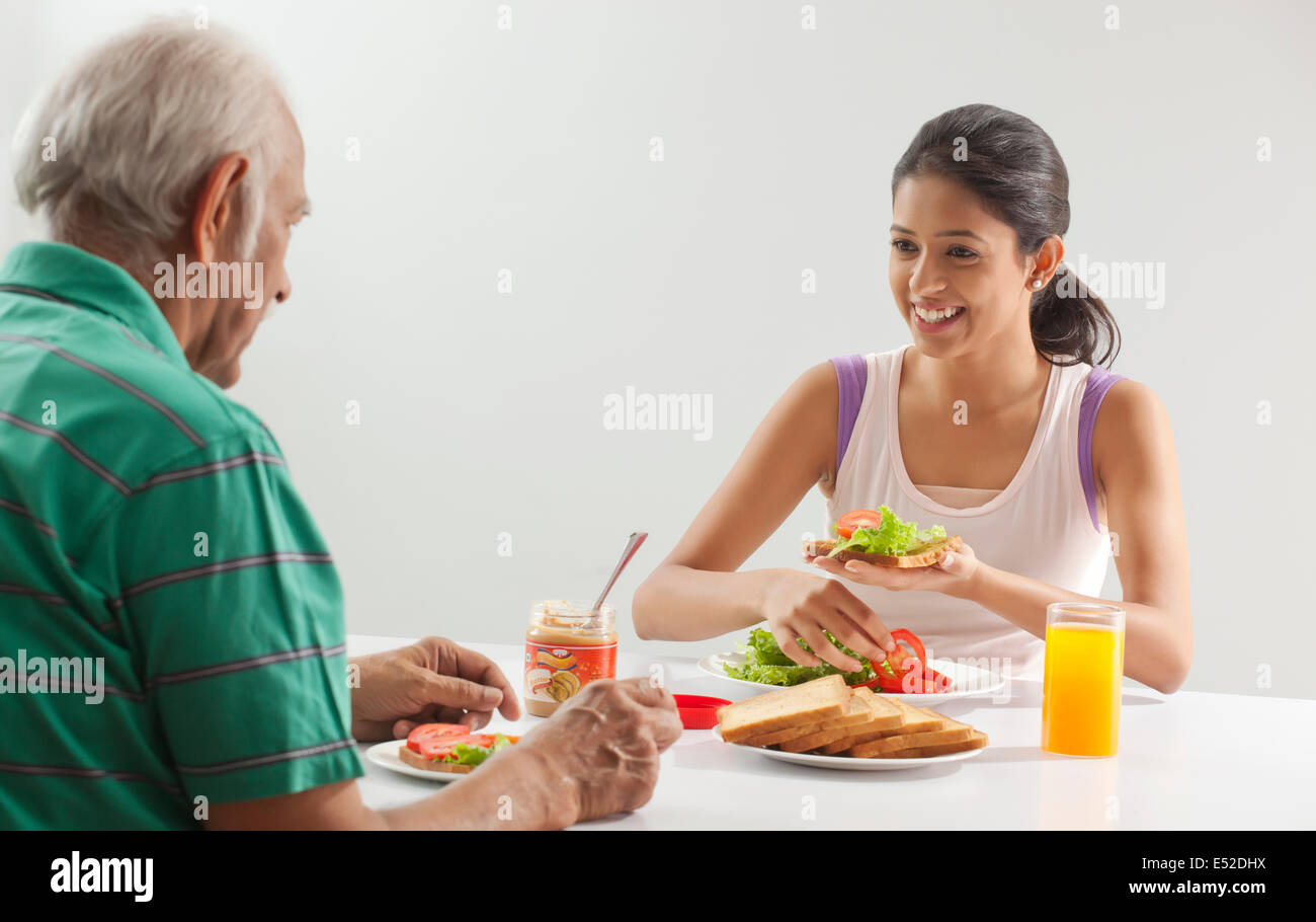 Grandfather and granddaughter eating breakfast Stock Photo - Alamy