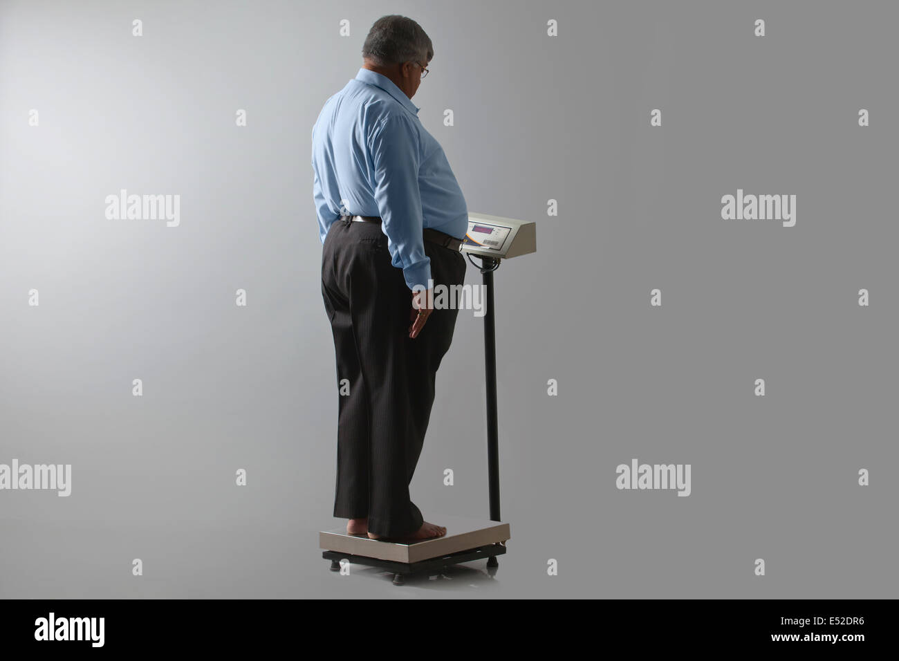 Obese man checking his weight Stock Photo - Alamy