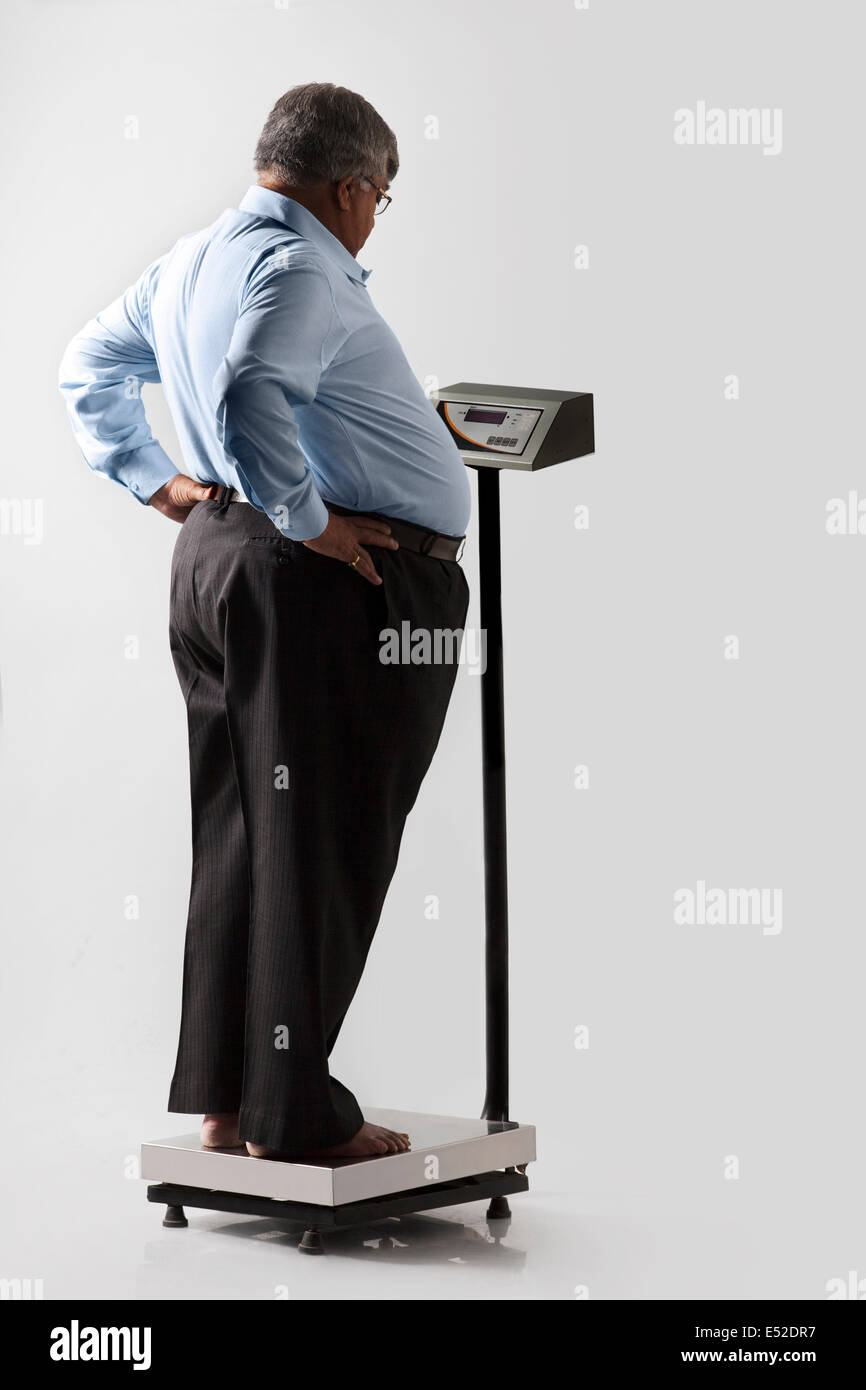 Obese man checking his weight Stock Photo - Alamy