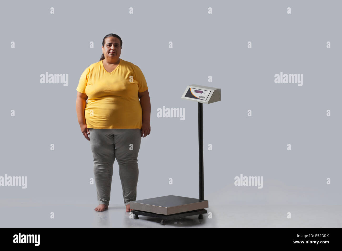 Portrait of obese woman with weighing scale Stock Photo - Alamy