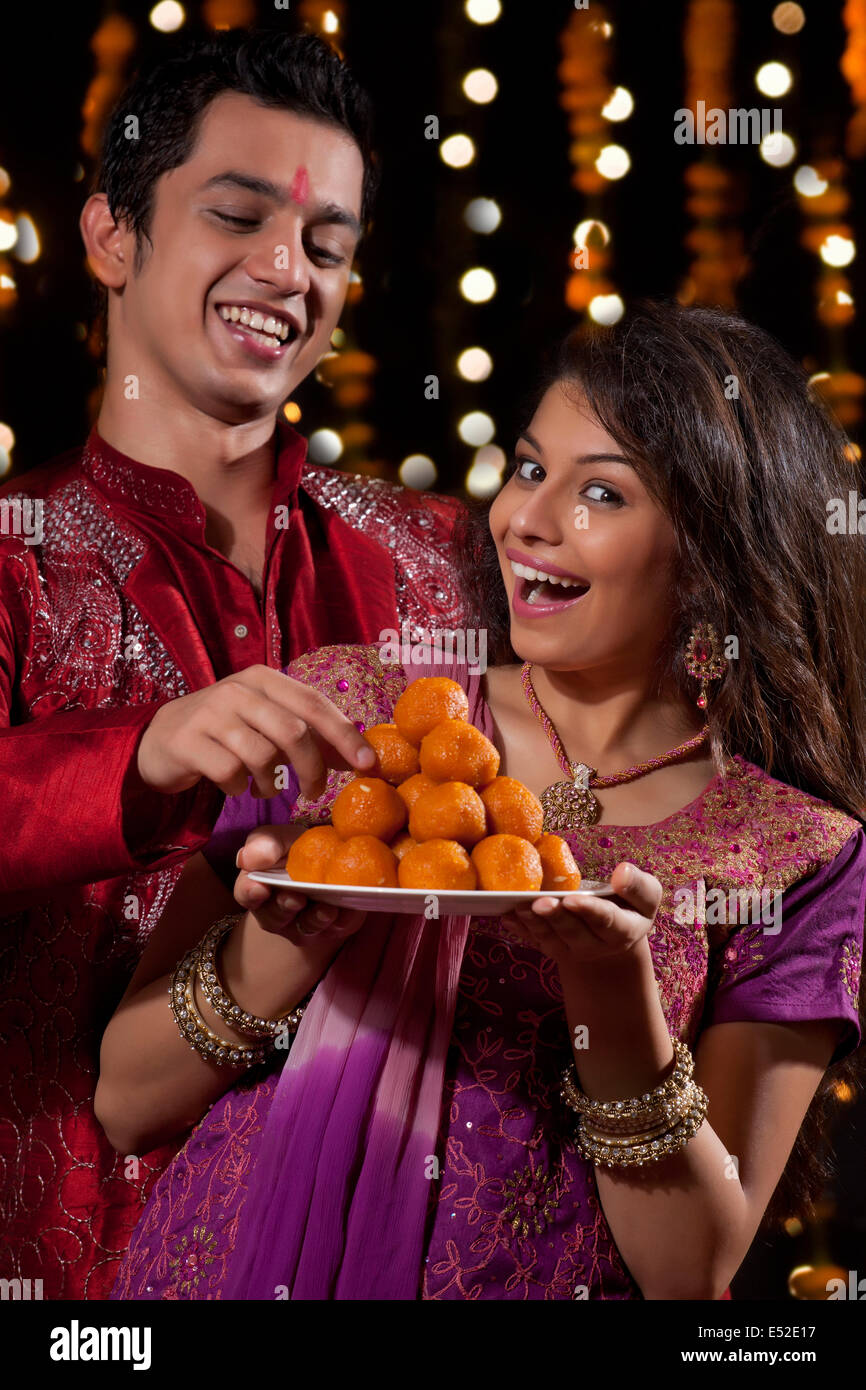 Man taking sweets from plate Stock Photo - Alamy