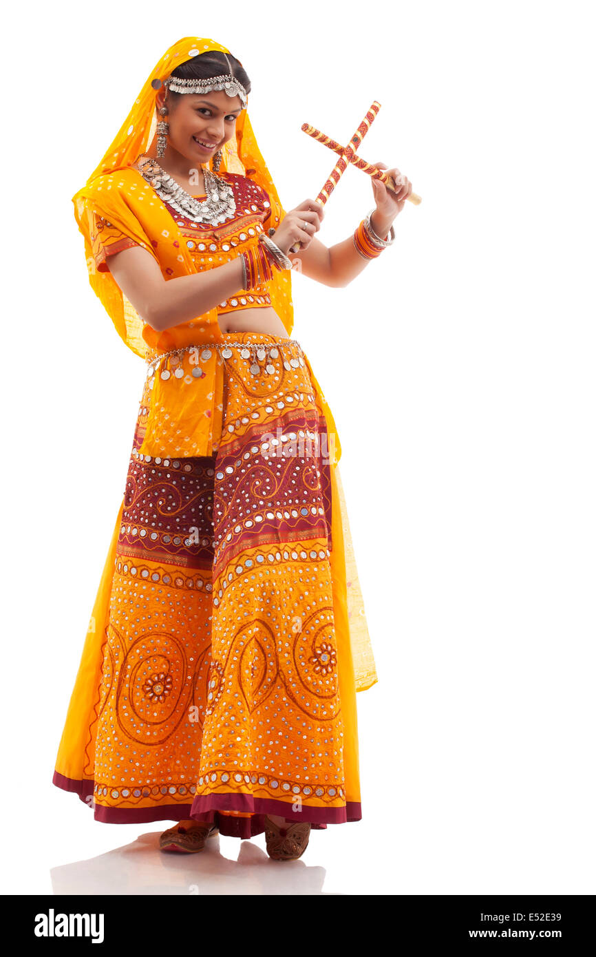 Portrait of young woman performing Dandiya Raas isolated over white ...