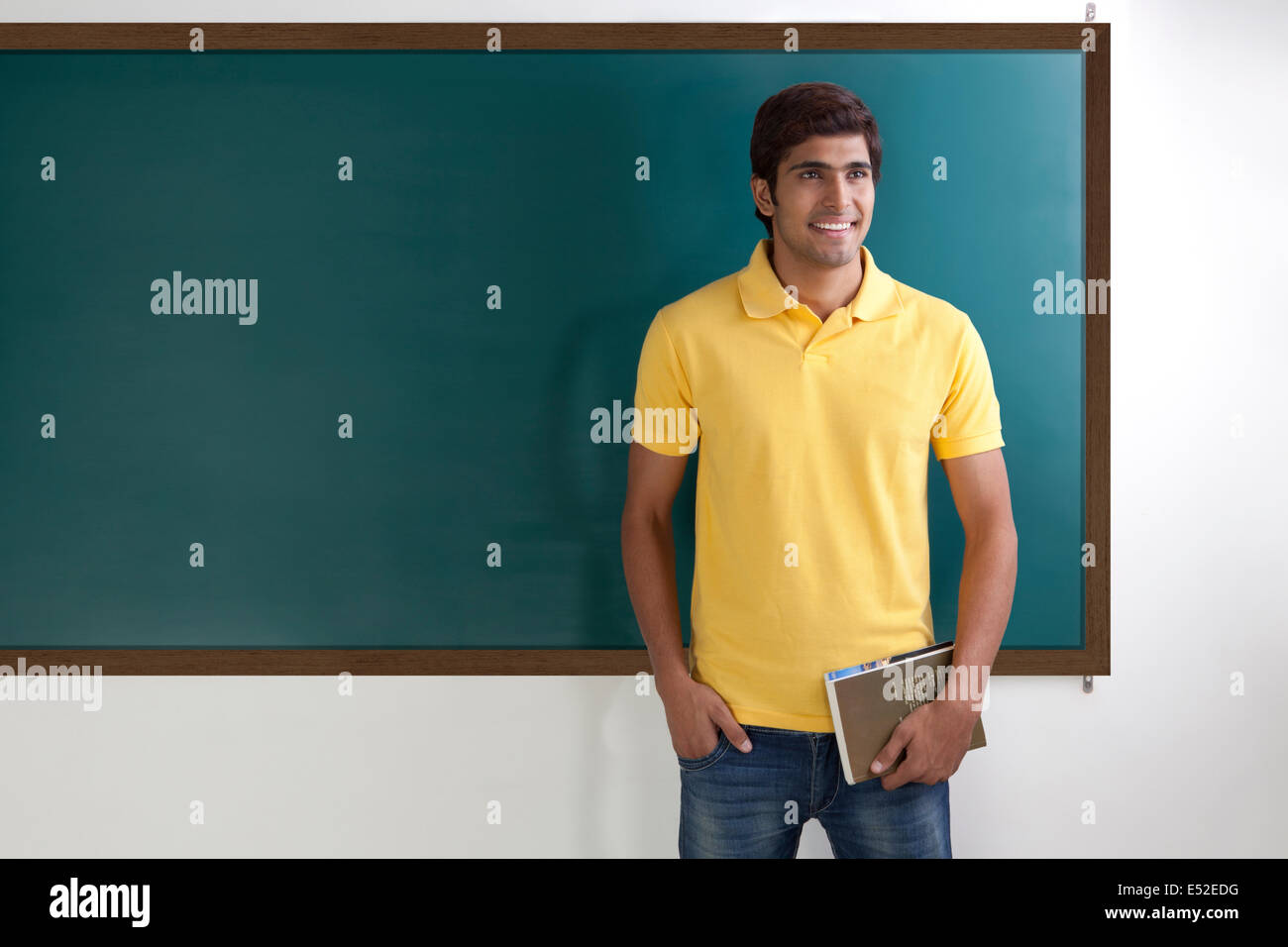 College student standing in front of blackboard Stock Photo - Alamy