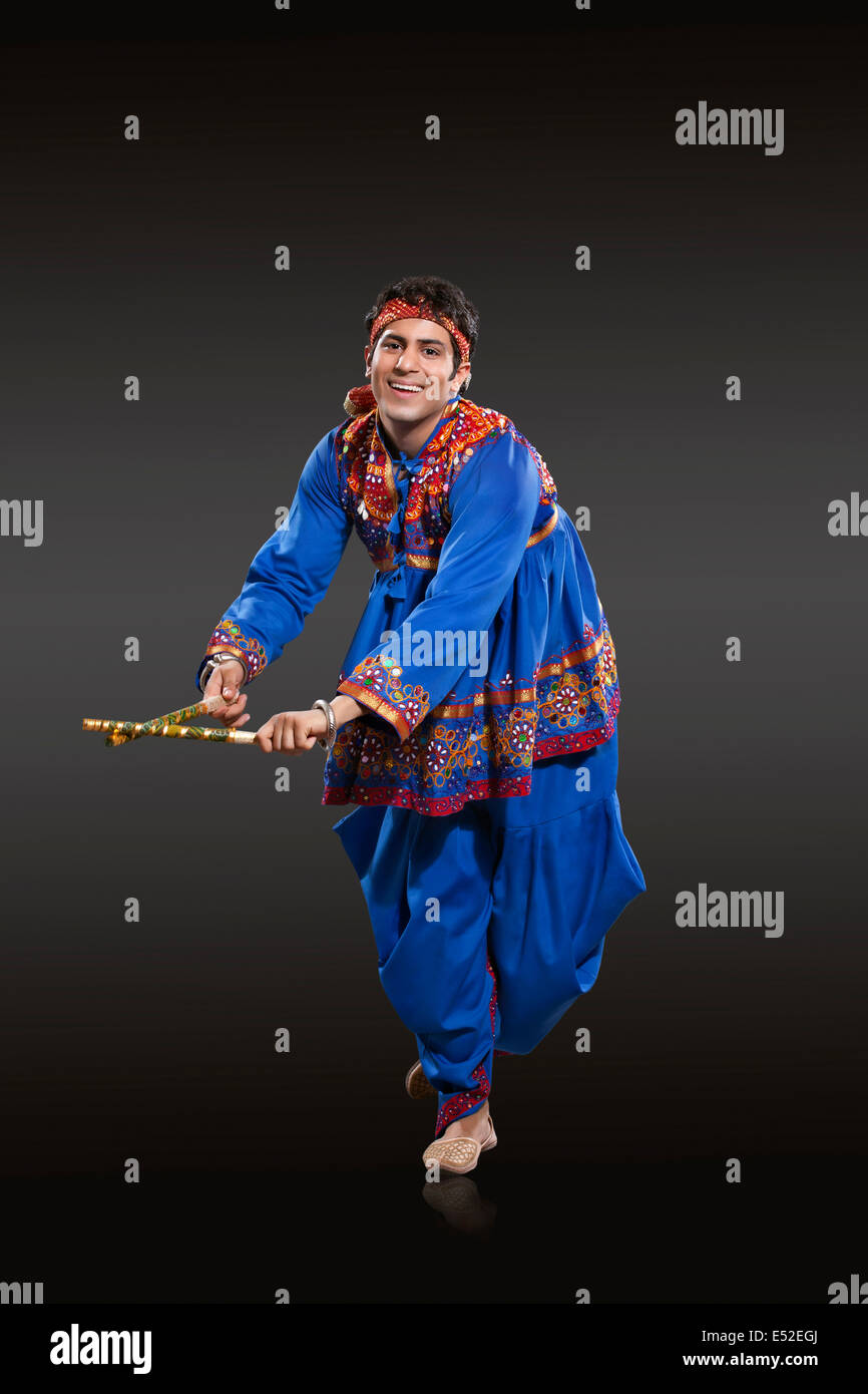 Full length portrait of Indian man in traditional wear performing ...