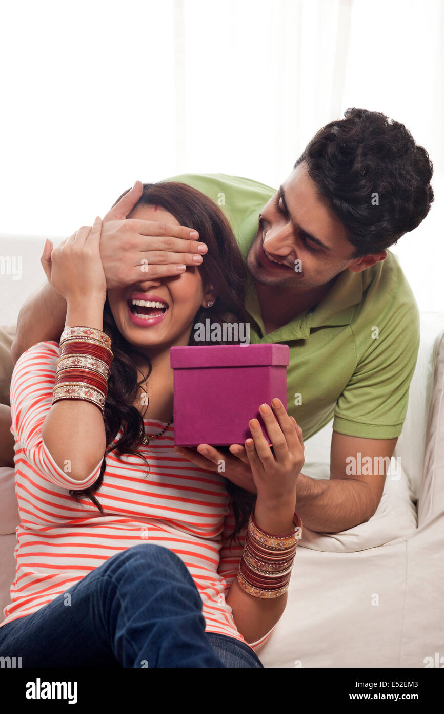 Man surprising a woman with a gift Stock Photo - Alamy