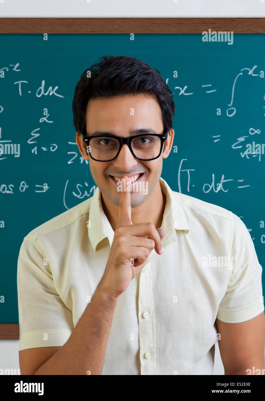 Portrait of college student gesturing to be silent Stock Photo - Alamy