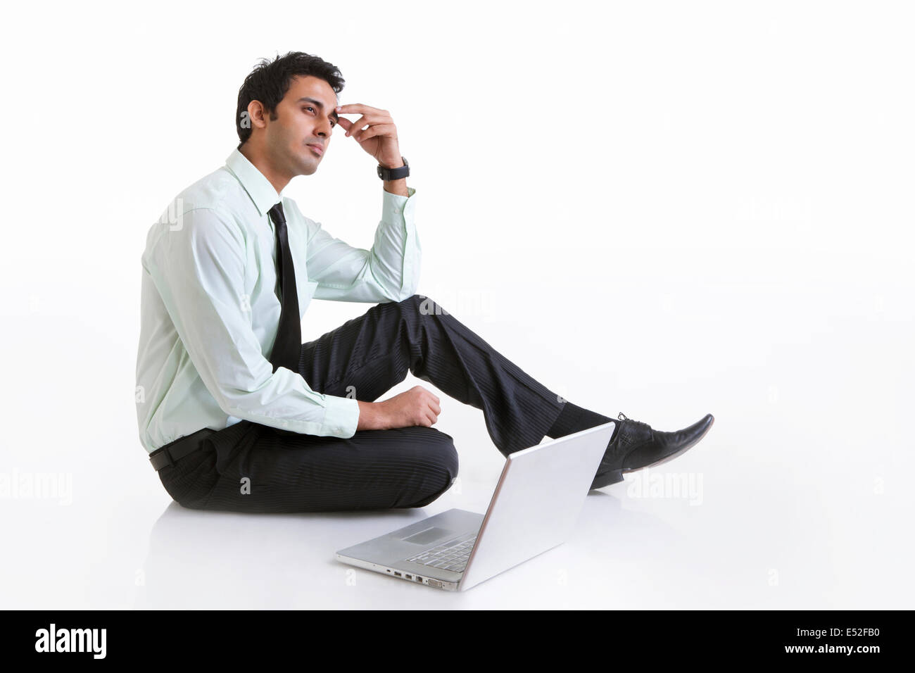 Business executive with laptop thinking Stock Photo - Alamy