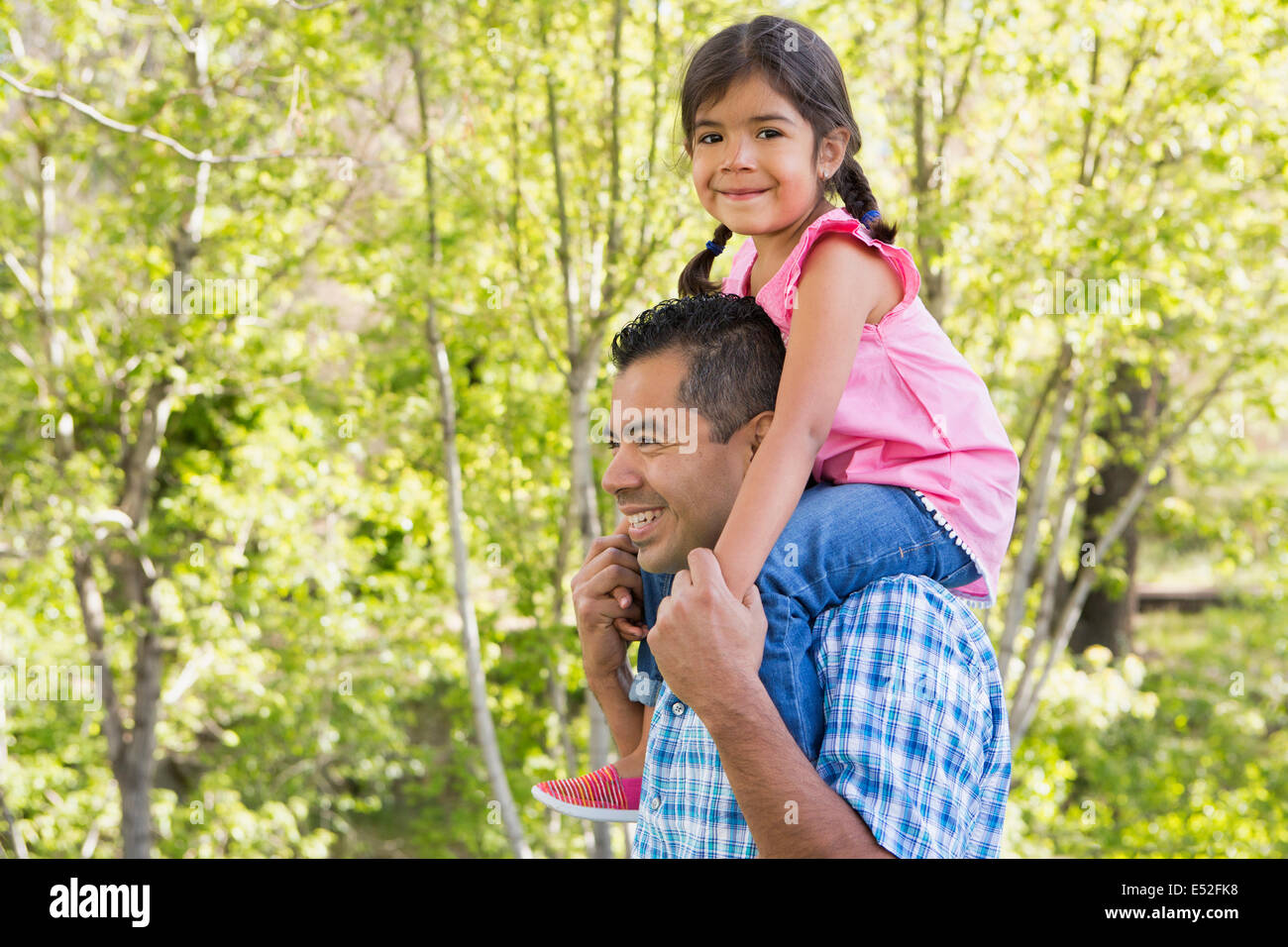 A man giving his daughter a piggyback ride on his shoulders Stock Photo ...